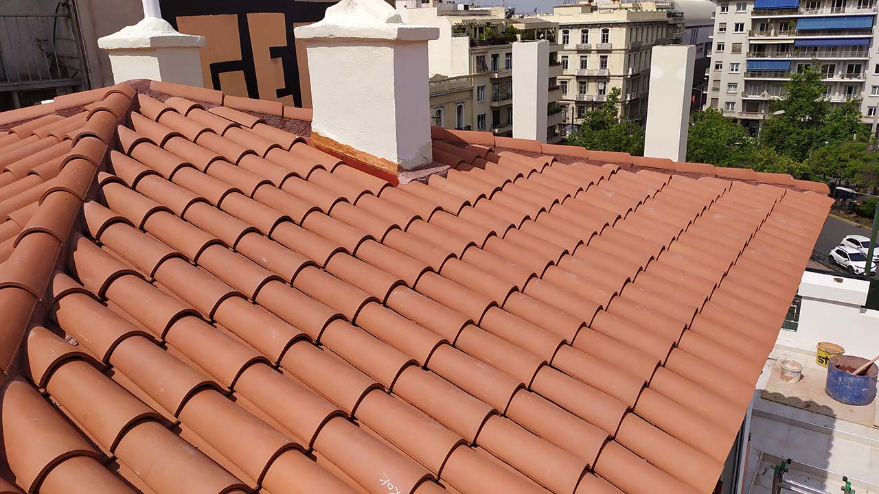Σκεπή με κόκκινα βυζαντινά κεραμίδια σε διατηρητέο κτίριο στην Αθήνα